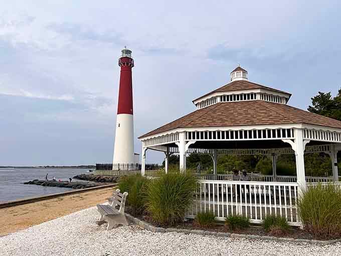The red-and-white lighthouse stands sentinel beside a charming gazebo, creating a postcard-perfect coastal scene that never gets old.