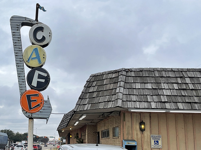 That vintage stacked "CAFE" sign rising above the wooden shingle roofline is basically a retro lighthouse guiding hungry travelers safely to shore.