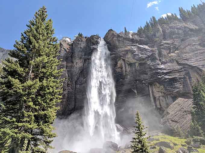 Bridal Veil Falls drops 365 feet of pure Colorado fury, with a historic powerhouse perched at the top like a tiny, fearless sentinel.