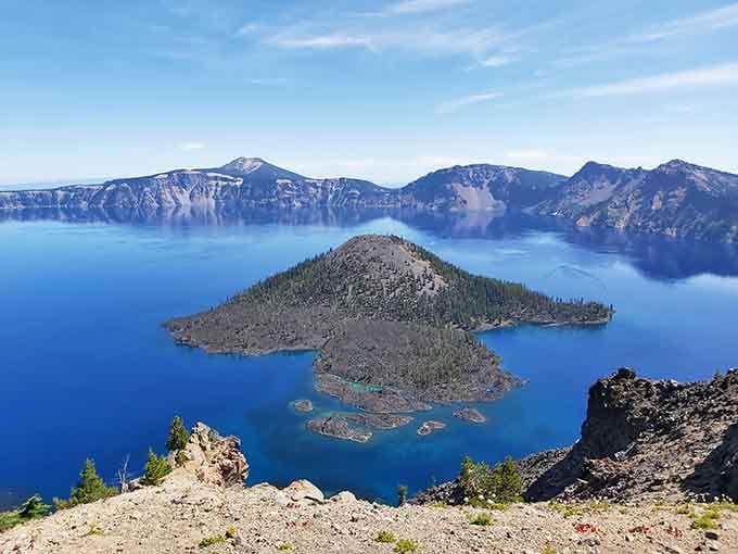 Wizard Island floats in impossibly blue water, looking like a miniature volcano vacationing inside its larger parent.