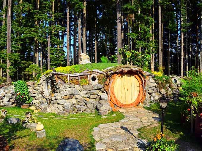 A glowing round door, stone walls, and a mossy roof make this woodland hideaway feel delightfully storybook real.