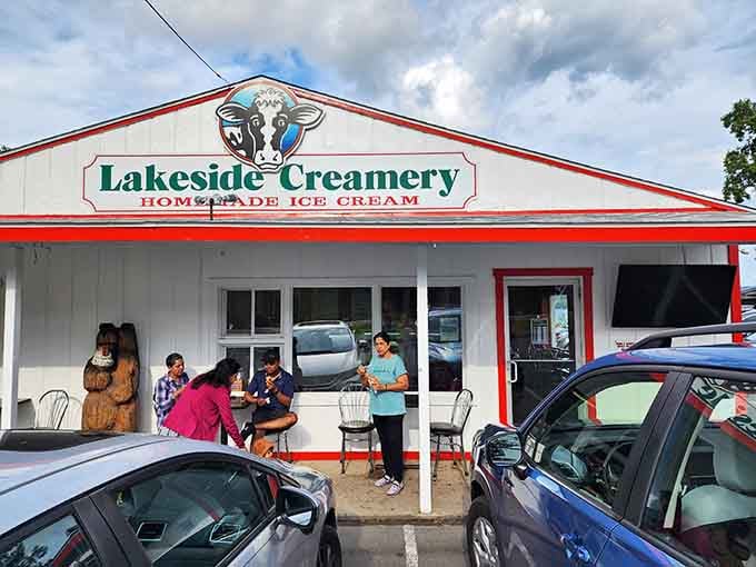 Happy faces, cones in hand, gathered outside Lakeside Creamery — that carved wooden bear approves of every single choice made here.
