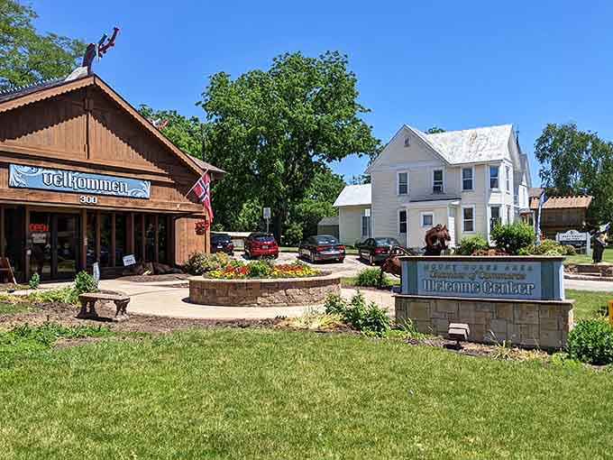 That welcome sign means business, flanked by flowers and shops that actually want you to stay awhile and browse.