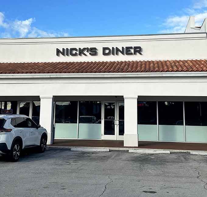 Clean white walls, terracotta roofline, and a bold nameplate: Nick's Diner means business before you even walk in.