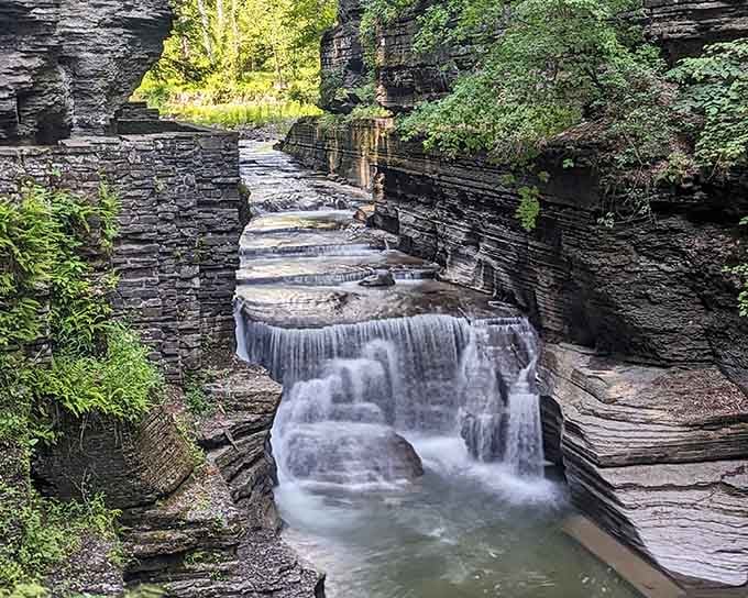 Water tumbling in silky ribbons down stacked shale steps creates a rhythm that feels almost hypnotically beautiful.