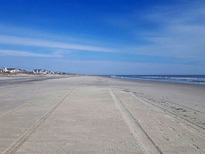 Miles of empty shoreline stretch toward the horizon &mdash; no crowds, no noise, just sand, sky, and sweet relief.