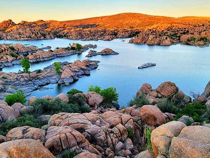 Watson Lake's granite boulders blush orange at sunset, cradling still blue water like a geological masterpiece.