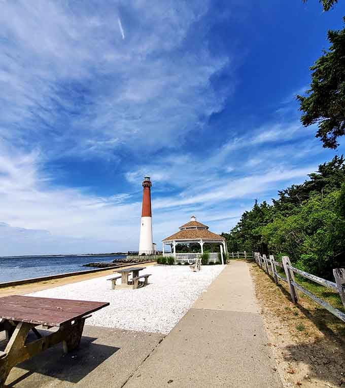 Under endless blue skies, this iconic lighthouse stretches tall while the gazebo offers shade and seaside serenity.