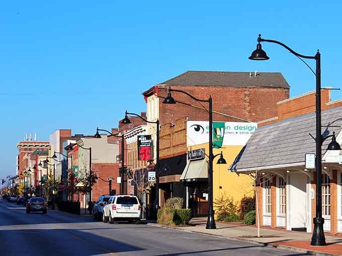 Warm lamplight and colorful storefronts stretch down Belleville's main corridor, where a lively street scene unfolds on an ordinary afternoon.