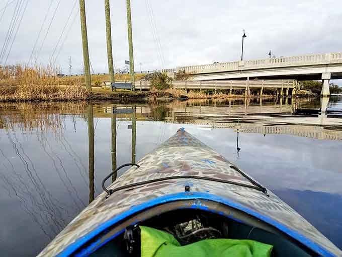 Reflections double the beauty as the kayak glides beneath an elegant bridge connecting past and present.
