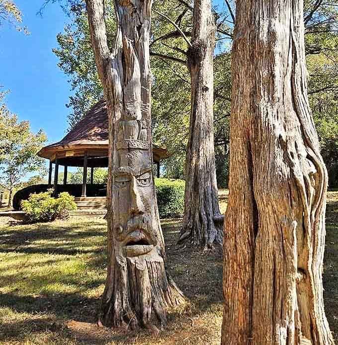 Tree trunk sculptures emerge from the bark like forest spirits frozen mid-conversation, each one uniquely expressive and charming.