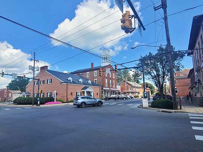 Strasburg's sunny intersection hums with quiet purpose, anchored by a classic brick building and a proud steeple.