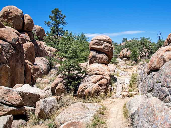 A narrow trail winds between stacked granite boulders that look like nature's own game of Jenga.