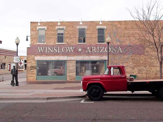 The bronze hitchhiker stands quietly beside the famous mural, forever waiting for that flatbed Ford to return.