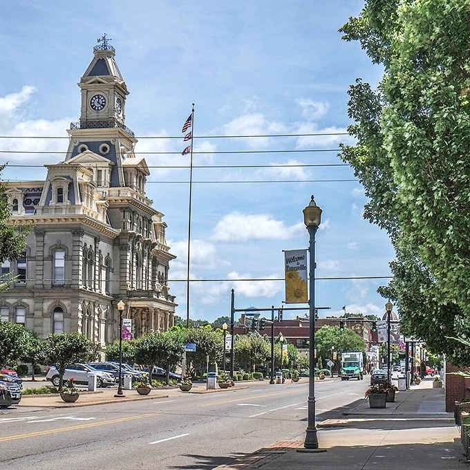 That "Welcome to Zanesville" banner flutters proudly beside a courthouse tower that could hold its own against any big-city skyline.