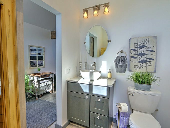Industrial lighting and a round mirror prove that farm life doesn't mean sacrificing your interior design standards.
