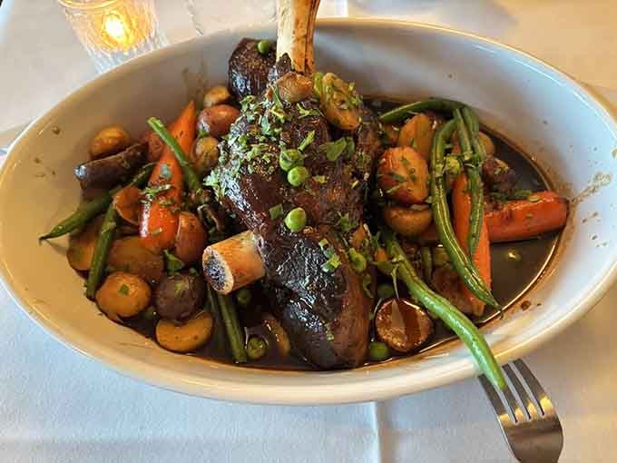 That bone standing proud tells you this braised shank means business, surrounded by vegetables that soaked up every drop.