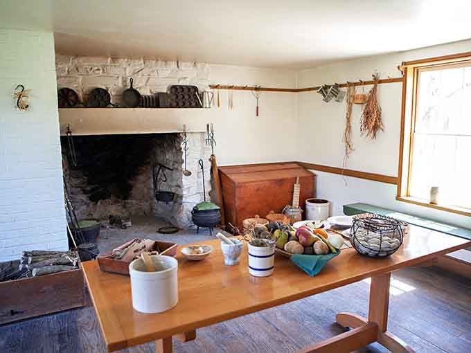 Cast iron pots, hanging dried herbs, and a heaping fruit basket make this hearth kitchen smell good just looking at it.