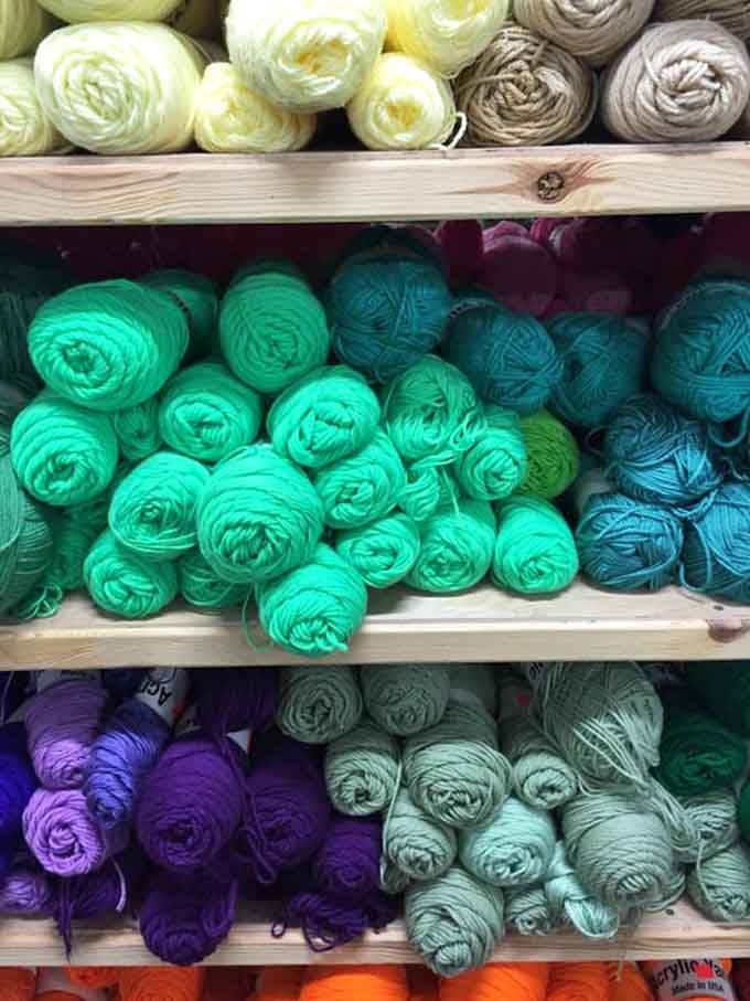 Yarn in every green imaginable, neatly bundled and begging to become someone's next cozy handmade masterpiece.