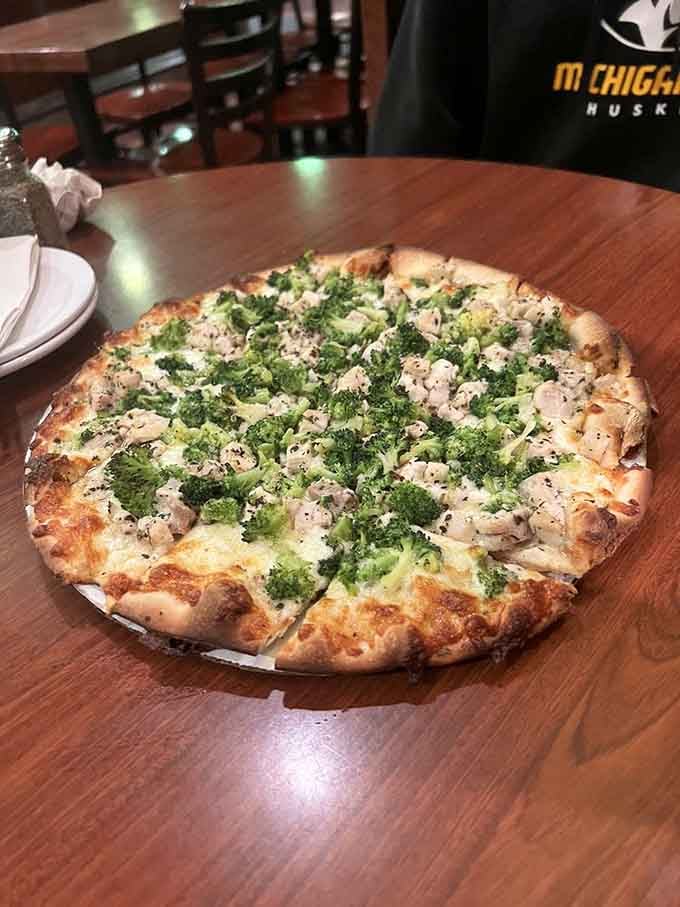 Garlic chicken pizza topped with enough greens to make you feel virtuous while absolutely not being virtuous at all.