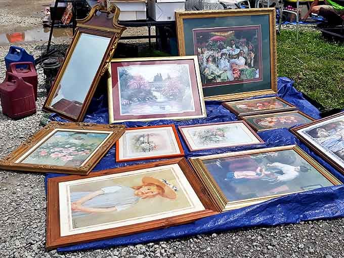 Framed art laid out on a tarp, proof that one person's attic is another person's gallery wall.