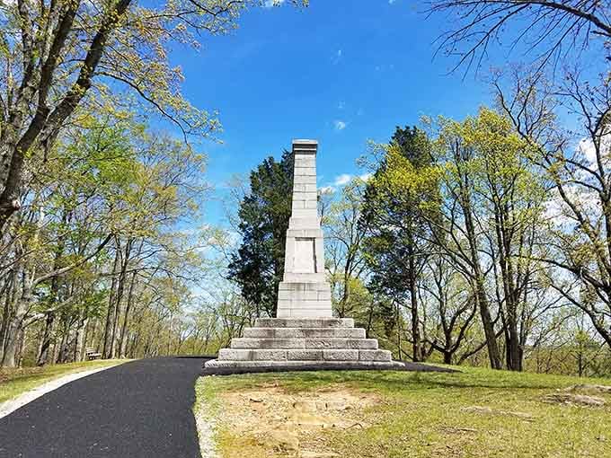 The Centennial Monument rises through spring's fresh canopy, marking the spot where everything changed on that October day.