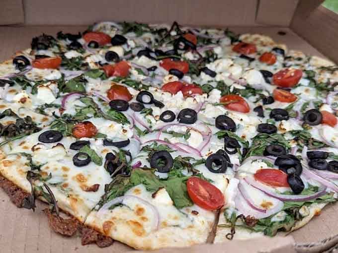Arugula, tomatoes, olives, red onion, and ricotta on a thin crust. This pizza came to impress, and it succeeded.