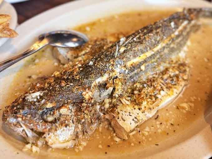 A whole sea bass roasted to perfection, glistening in its own juices. This dish means serious business, and it knows it.