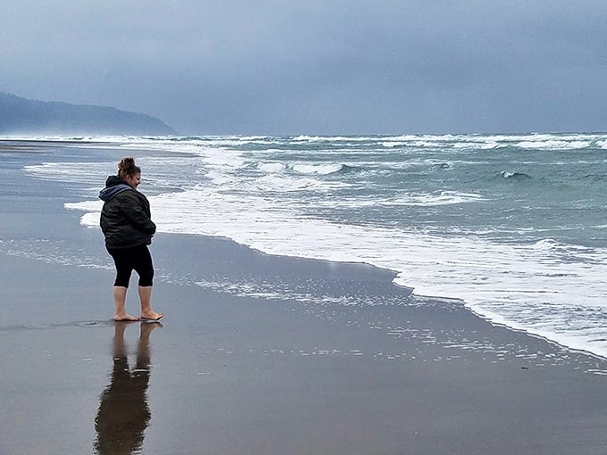 Standing barefoot at the water's edge in a jacket. That's the Oregon Coast experience in one perfect, honest photo.