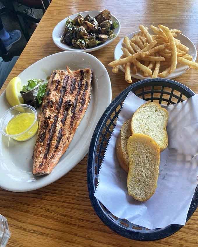 Grilled fish, crispy fries, roasted brussels sprouts, and warm bread. This table has its priorities completely sorted out.