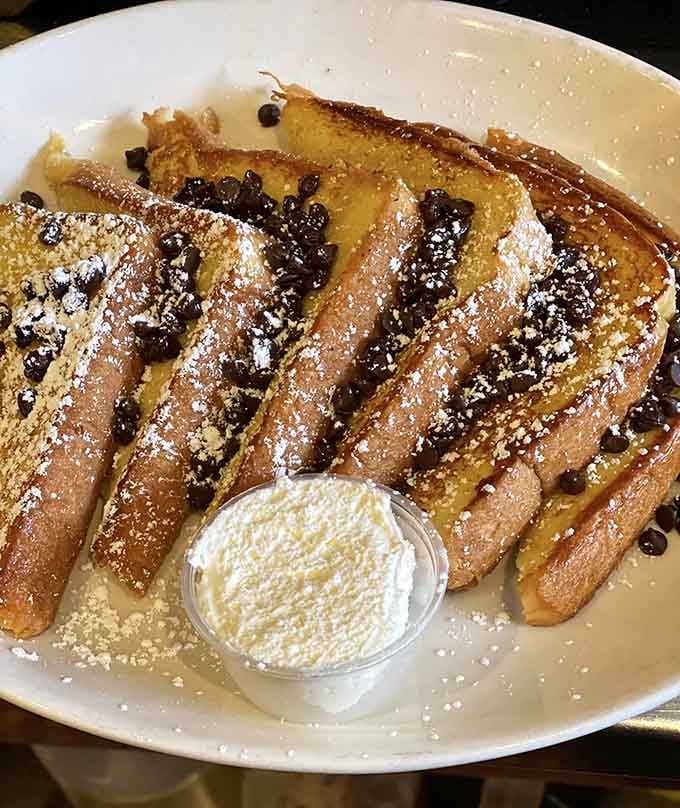 French toast dusted with powdered sugar and scattered with chocolate chips, because breakfast deserves a little drama.