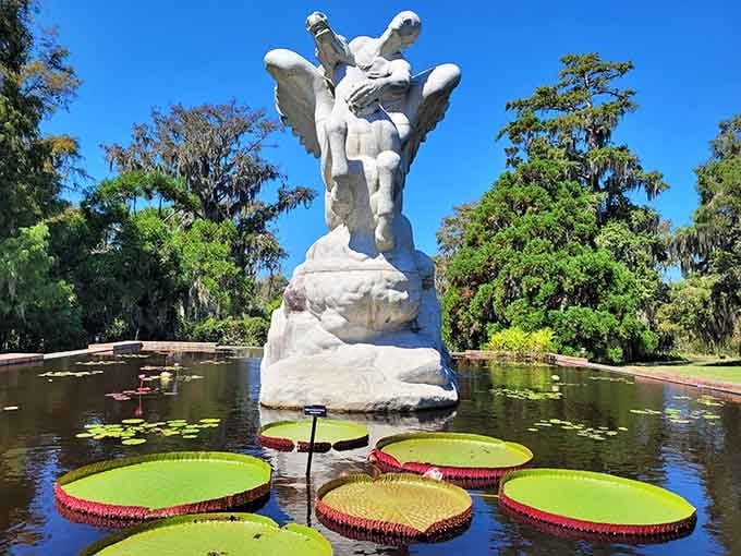 Giant lily pads float like nature's dinner plates while a classical sculpture watches over this impossibly serene scene.