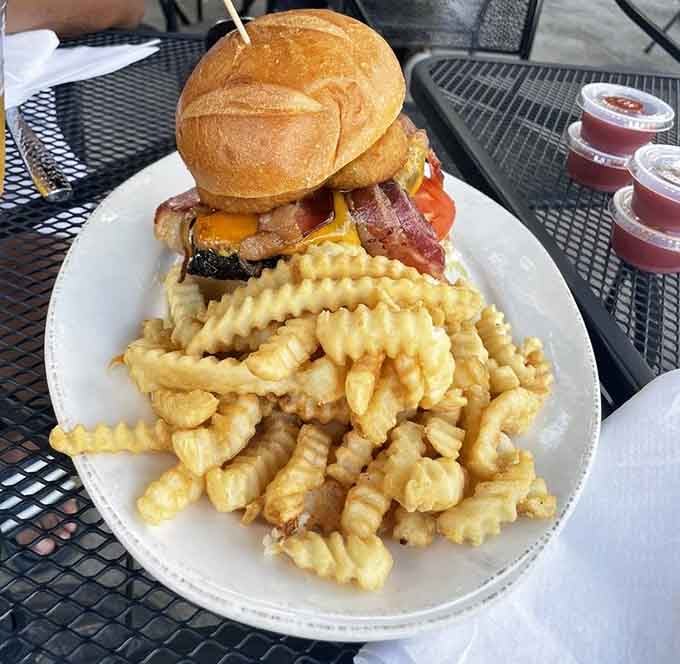 A towering burger stacked with bacon and cheese, flanked by crinkle-cut fries — lunch just became a life event.