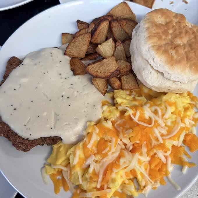 Country fried steak smothered in gravy, scrambled eggs, home fries, and a biscuit, this plate means serious business.