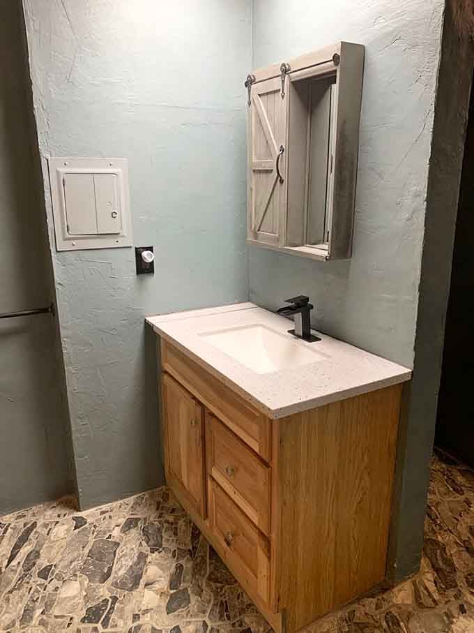 Even the bathroom sink gets the cave treatment, proving modern plumbing works anywhere with enough determination.