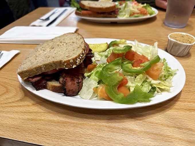 A generous pastrami sandwich alongside a crisp garden salad, proof that Cecil's knows how to balance a plate beautifully.