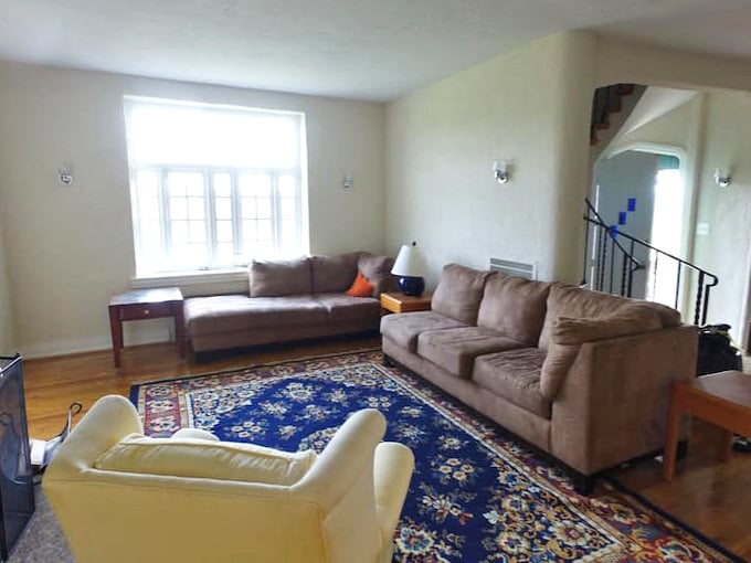 A living room spacious enough for the whole kingdom, complete with rugs that tie the royal room together beautifully.
