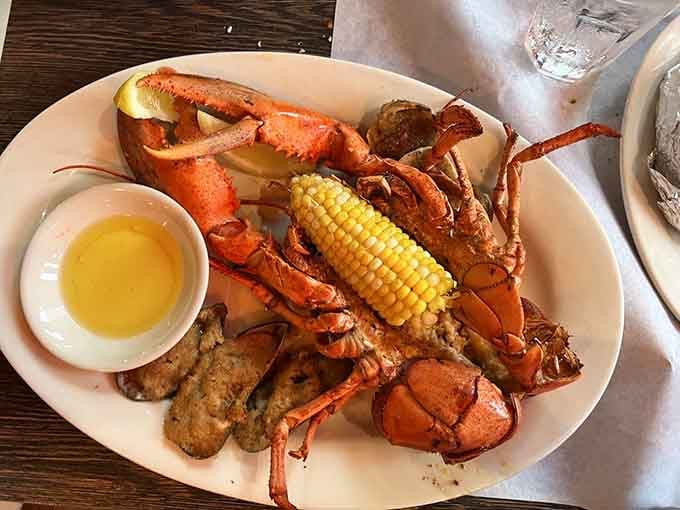 A whole lobster with corn, clams, and butter. This plate is basically a summer vacation on a dish.