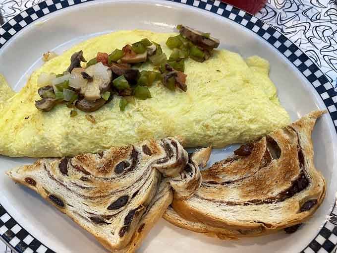 A fluffy veggie omelette paired with cinnamon raisin toast, proof that breakfast here means serious business.
