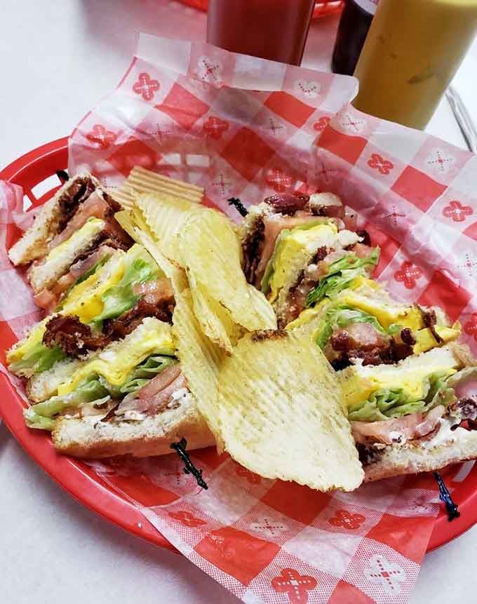 Stacked high, served in a red basket with chips, this club sandwich means serious, delicious business.