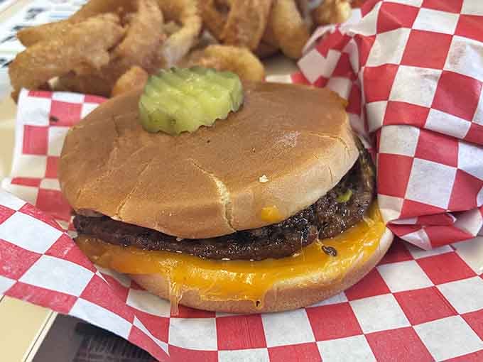 A cheeseburger with melted cheddar and a pickle on top. Simple, honest, and completely satisfying.