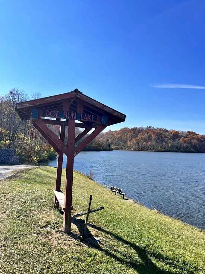 The Doe Run Lake sign has seen things, and that gorgeous stretch of autumn water behind it tells the whole story.