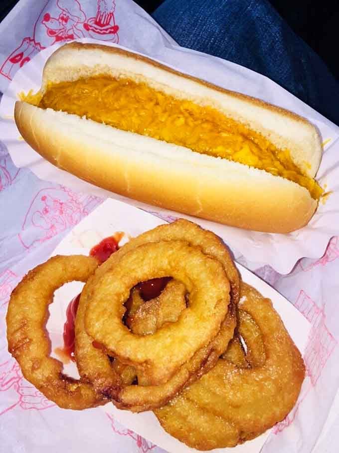 A foot long coney loaded with cheese beside golden onion rings, this combo deserves its own national holiday.