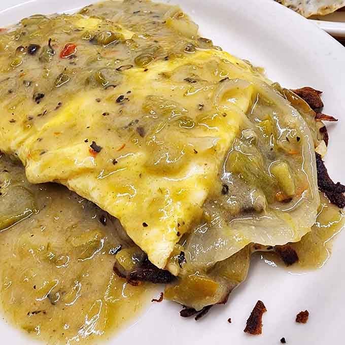 This is what happens when eggs meet scratch-made green chili and crispy hashbrowns underneath, a plate that fixes everything.