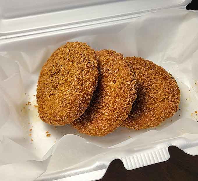 Three perfectly golden crab cakes, stacked like edible poker chips, daring you to eat just one.