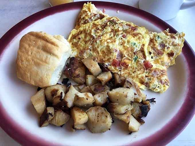 A loaded omelet with home fries and a biscuit. This is what a good morning actually looks like.