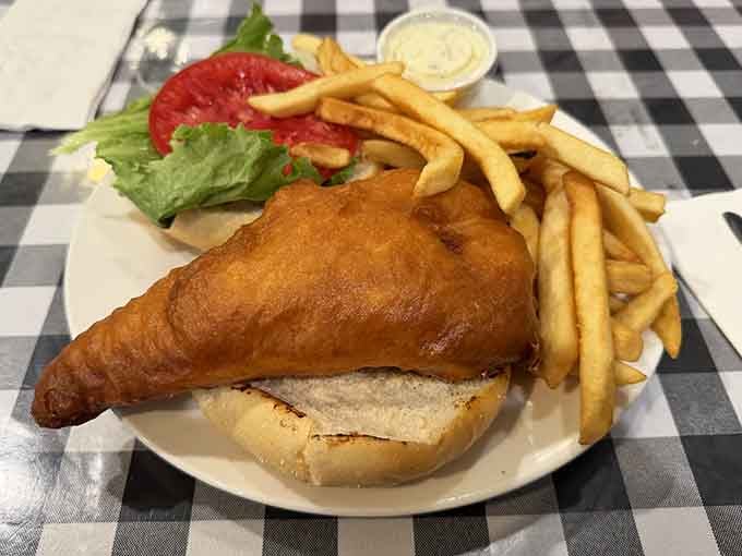 Golden, crispy battered fish spilling over a soft roll with fries alongside, Friday nights were made for exactly this.