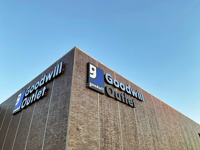 The bright blue sky provides a beautiful backdrop for the bold, welcoming signs on this historic brick outlet building.