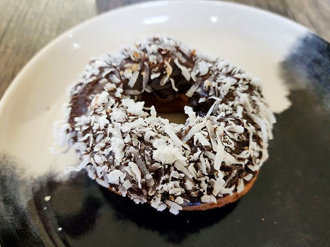 Chocolate glaze meets shredded coconut in a donut that somehow tastes even better than it looks sitting on that plate.