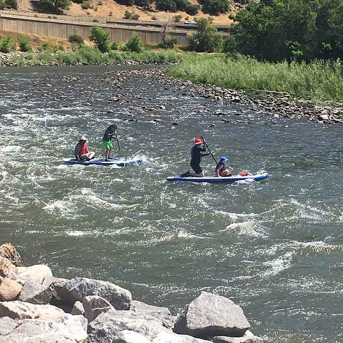 Paddleboarders glide through the Colorado River below, making water sports look easier than parallel parking ever was.